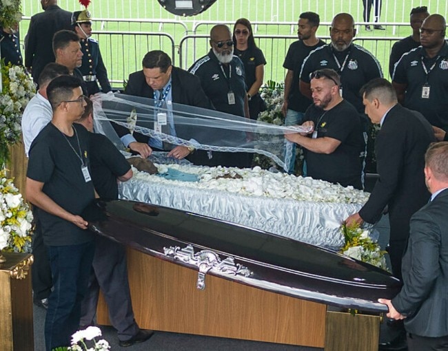 Funeral workers uncover the coffin of the late Brazilian soccer great Pele