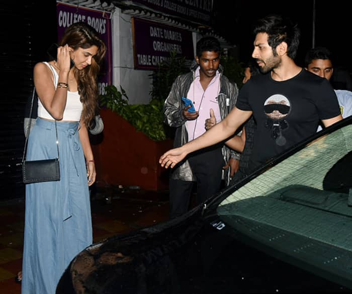 Kartik Aaryan extends to help Dimple Sharma to get into the car.