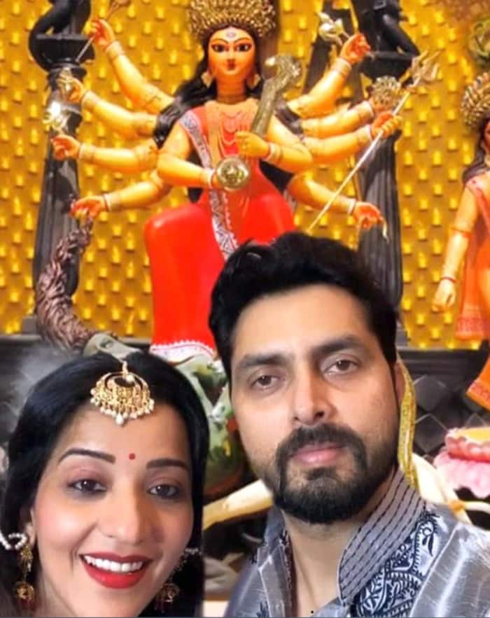 Monalisa and Vikrant are happily striking pose with the goddess Durga
